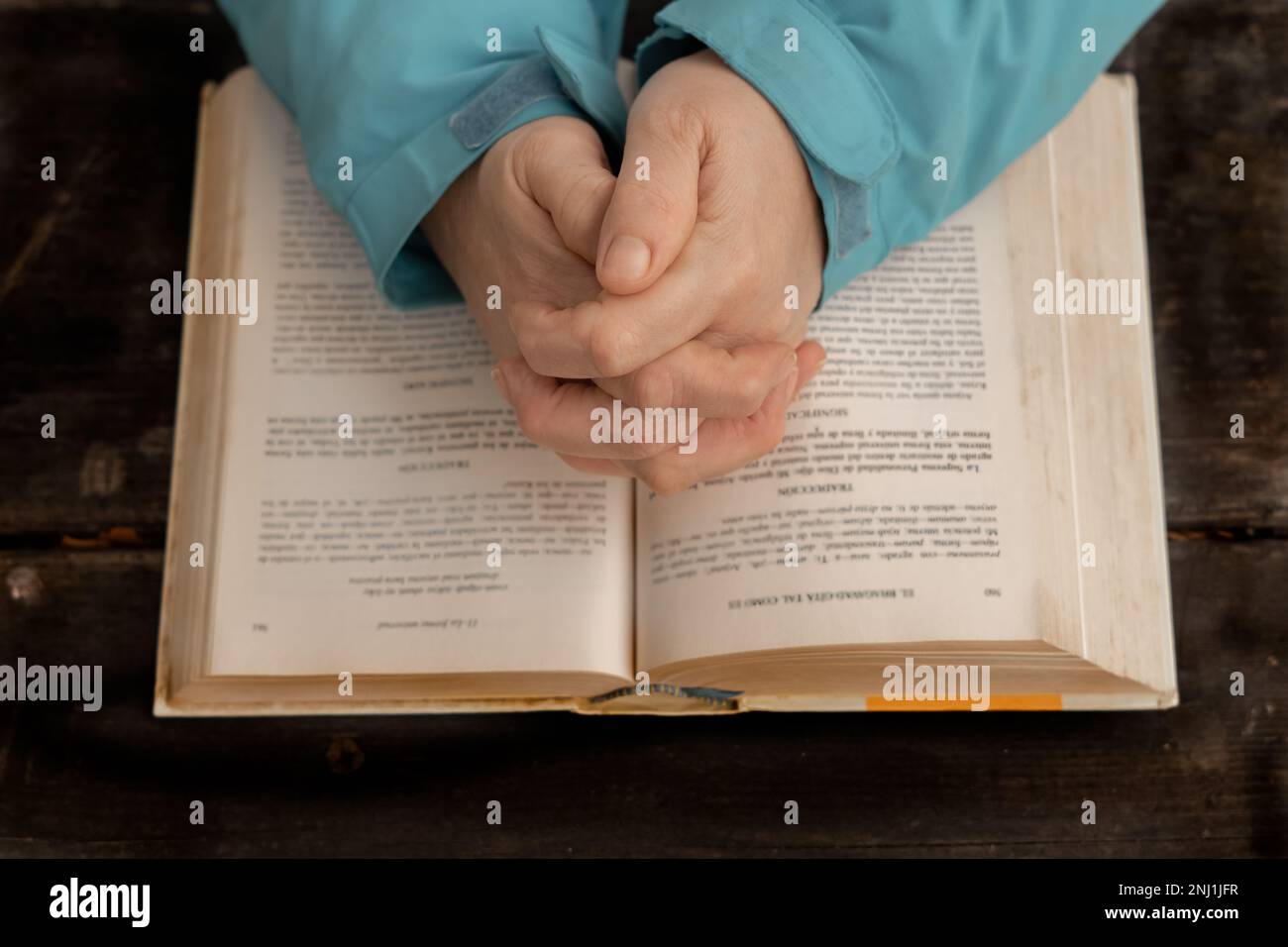 woman with her hands on top of a holy book in prayer posture Stock ...