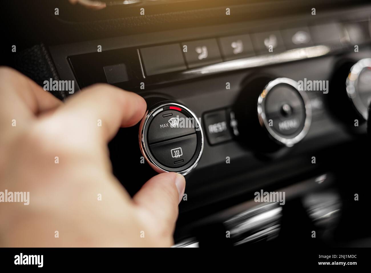 Closeup of hand adjusting the conditioner in a modern car. Dashboard ...