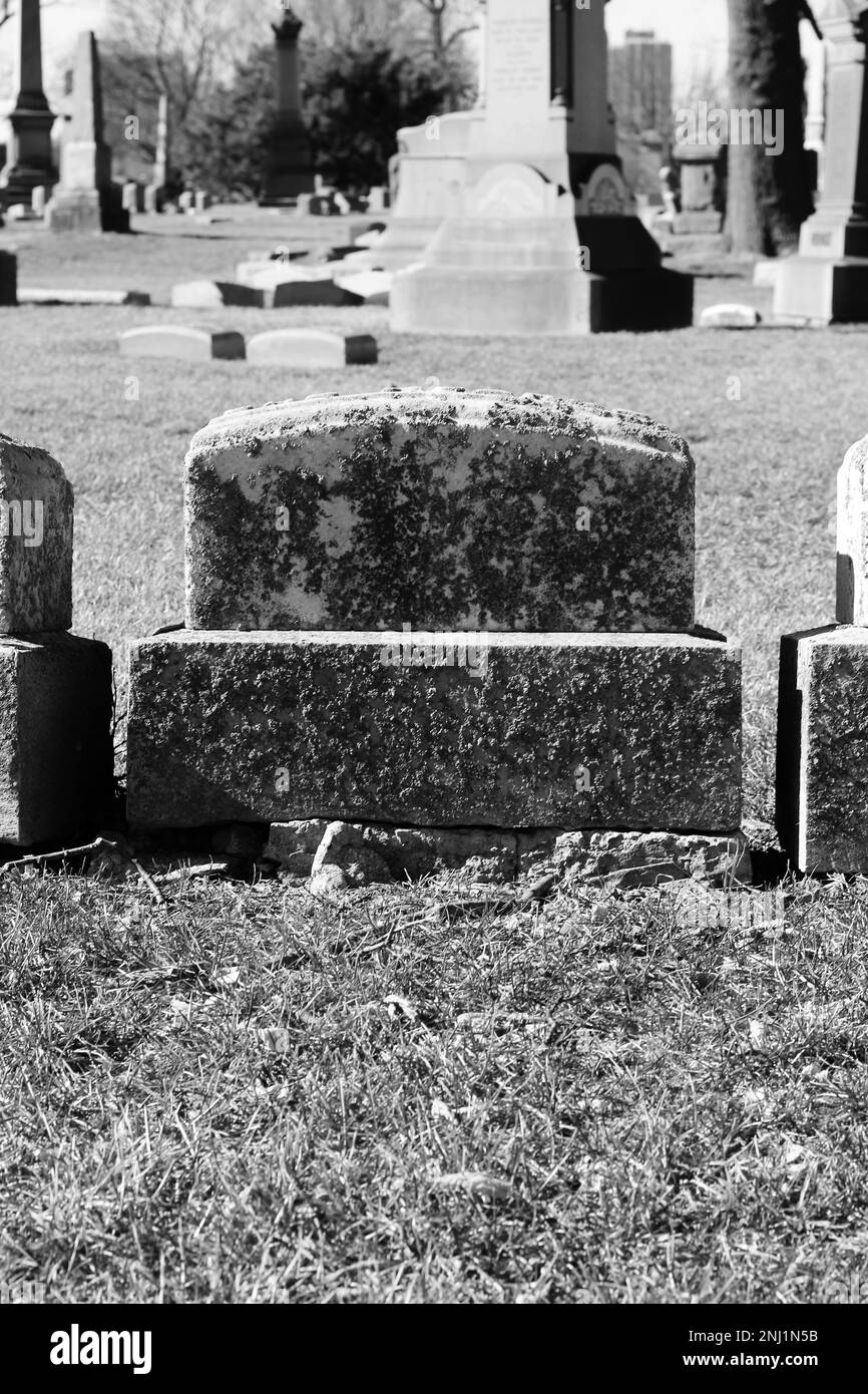 A worn and weathered old tombstone with a blank epitaph and room for ...