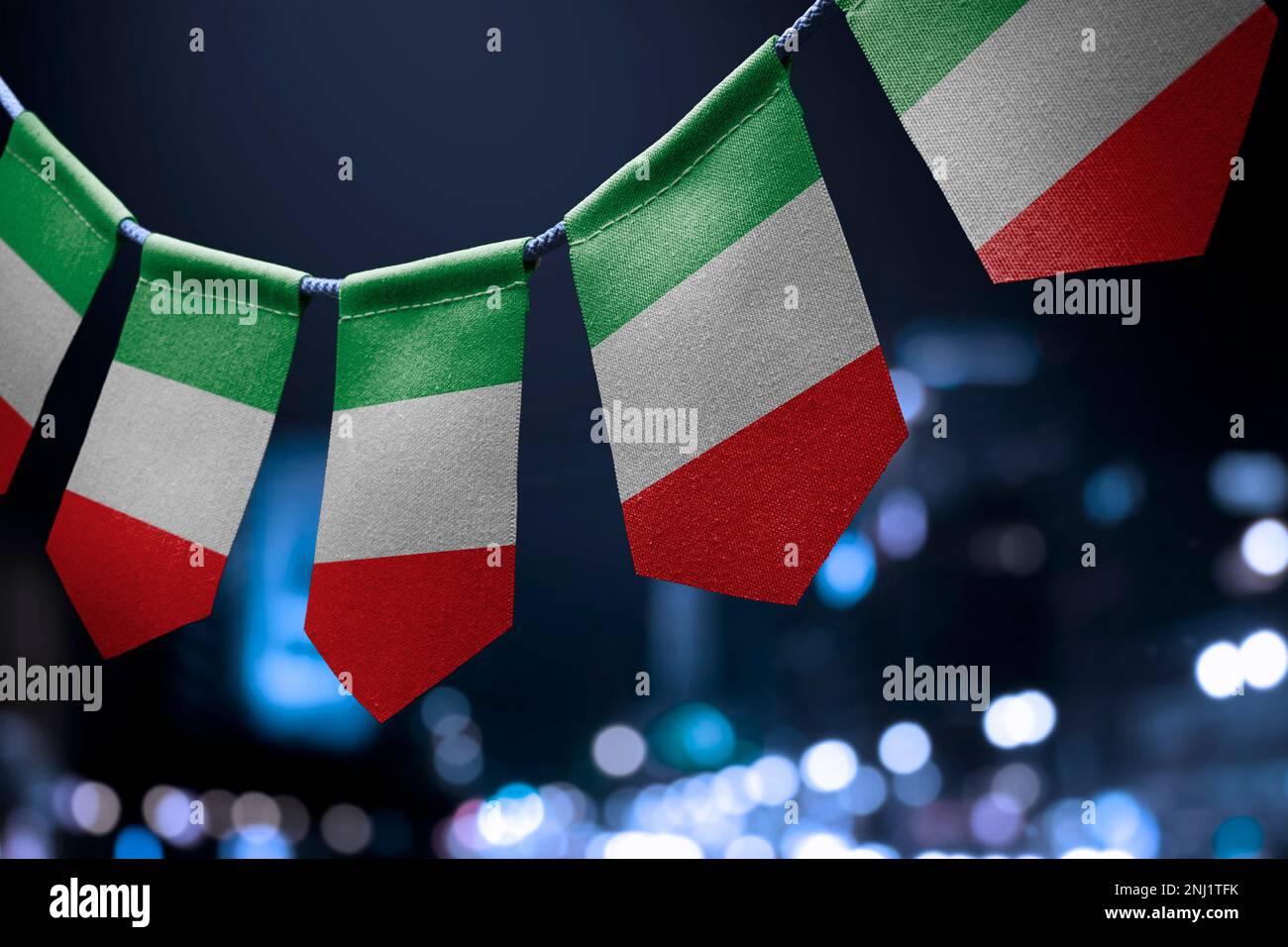 A garland of Italy national flags on an abstract blurred background ...