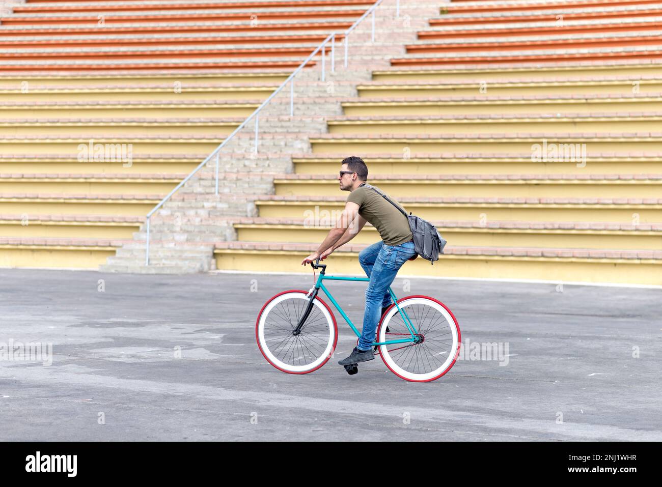 Side view of a young man is wearing sunglasses and carrying shoulder ...