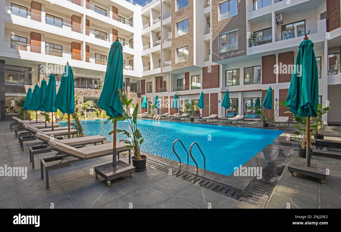 Large swimming pool with sun loungers at a luxury tropical hotel apartment resort Stock Photo ...