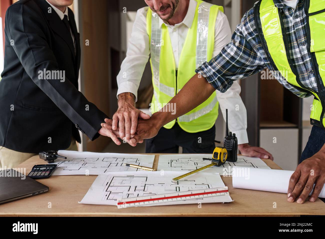 Architecture team stacking hands working together. Architectural plan ...