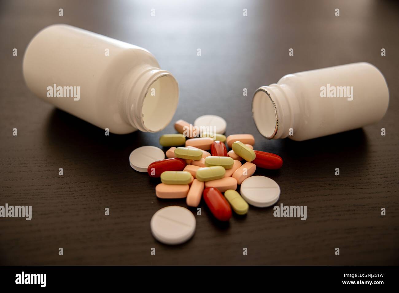 Jars of medicines Scattered aspirin tablets Green pink and red tablets ...