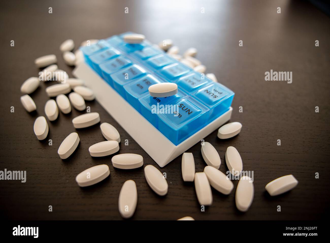 A blue pill Tablets are on the lids of cells of different days of the ...