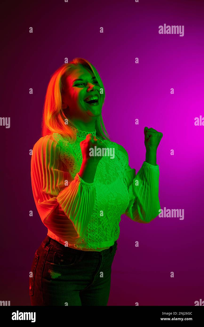 Success. Happy excited young woman posing with winning look over ...