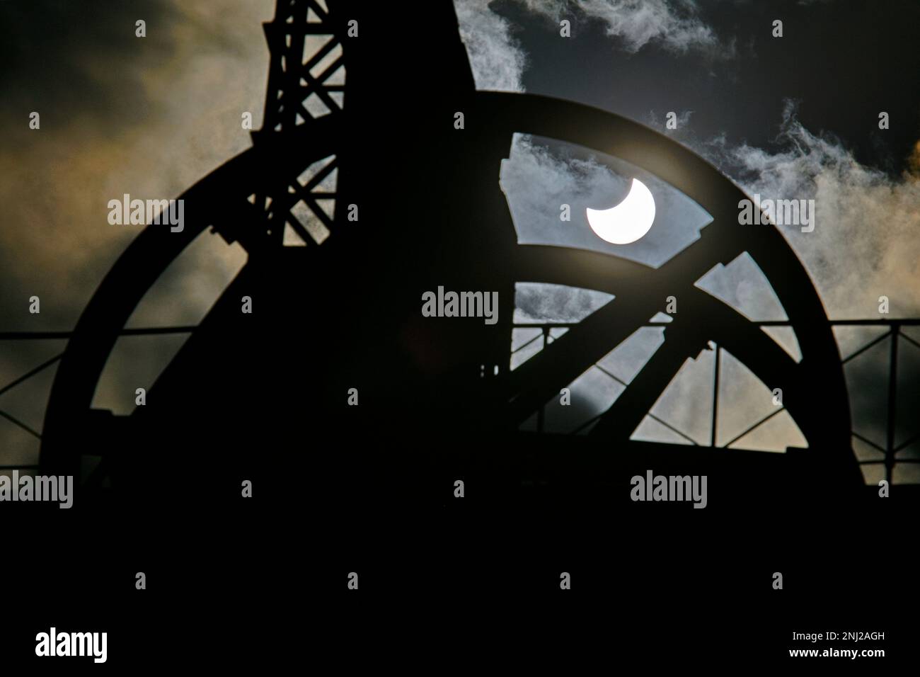 A partial solar eclipse can be seen above the historical mining tower ...