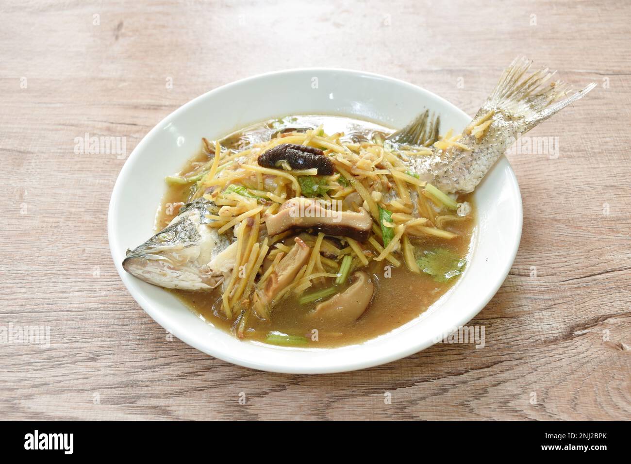 steamed bass fish dressing soybean gravy sauce topping slice ginger and ...