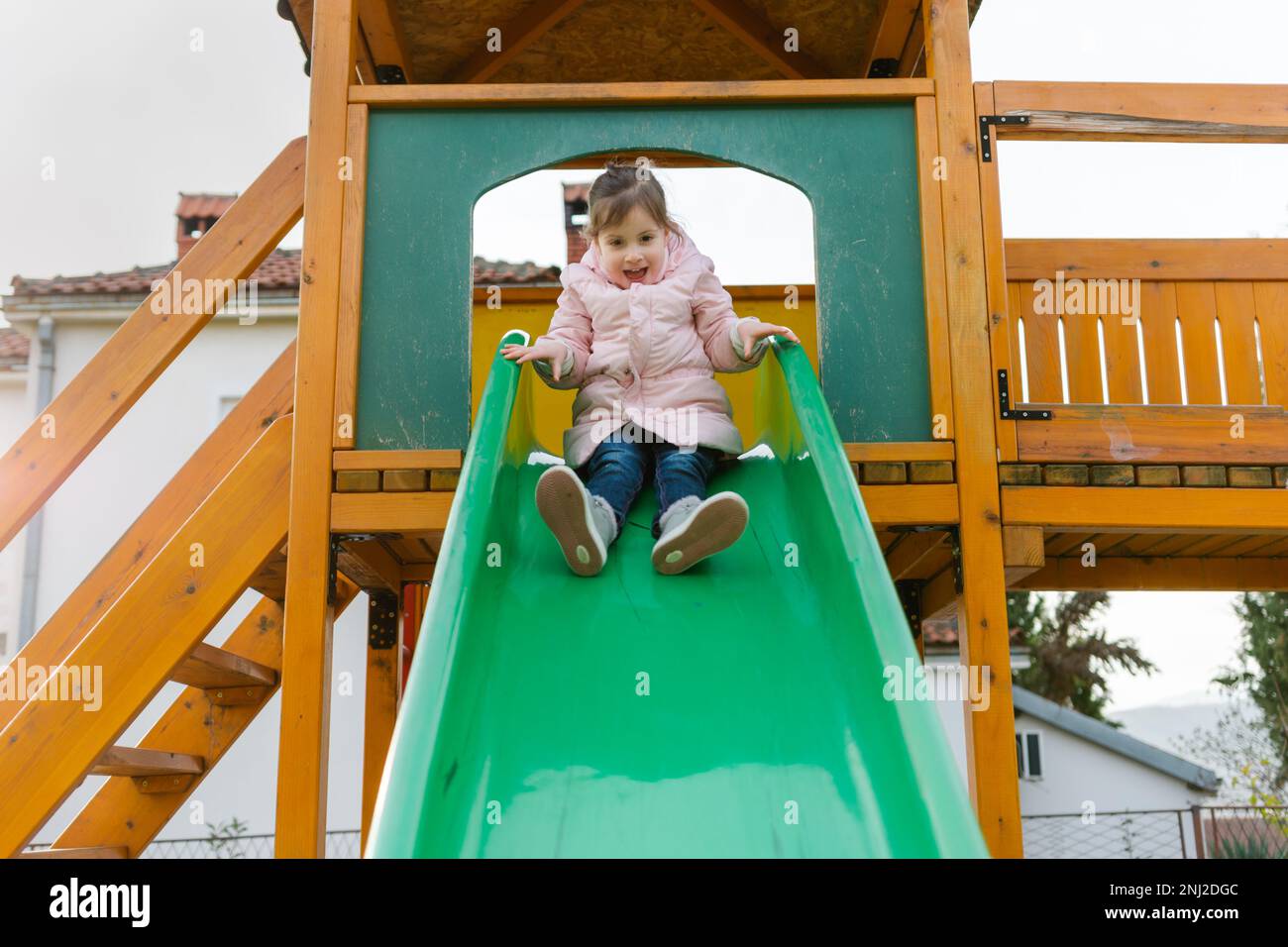 Cute little girl having fun while sliding at playground Stock Photo - Alamy