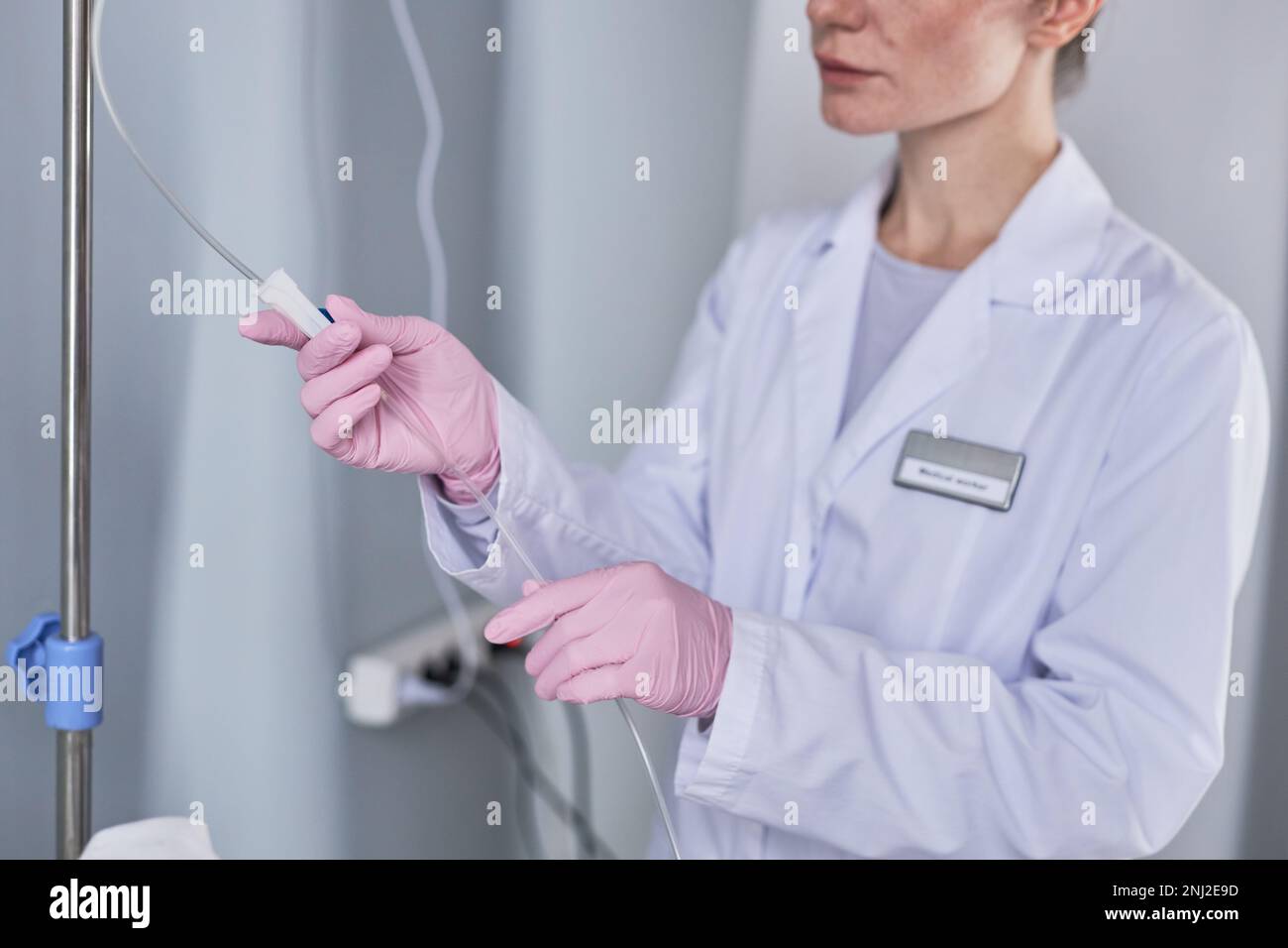 Minimal closeup of young nurse adjusting IV fluid setup in hospital ...