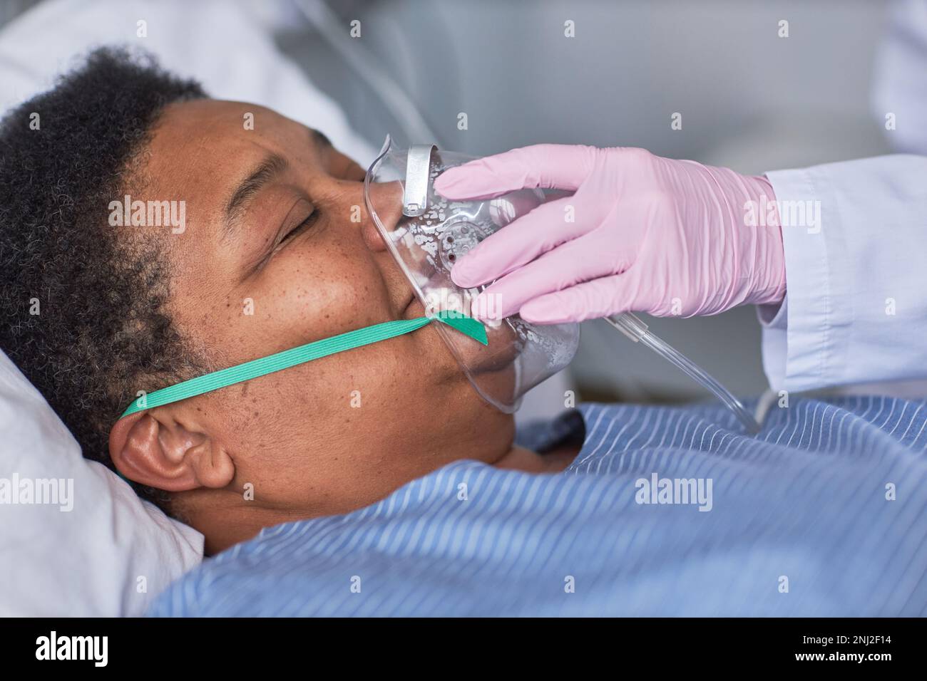 Doctor placing oxygen mask hi-res stock photography and images - Alamy