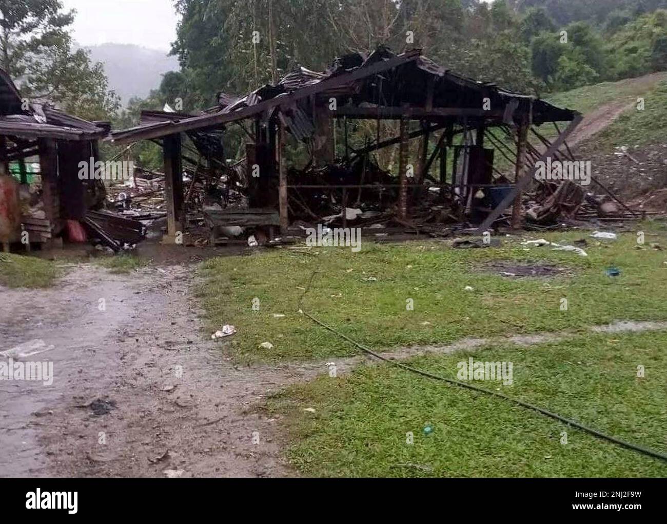 Debris are scattered around destroyed wooden structures near Aung Bar ...