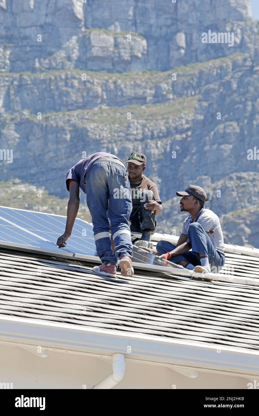 Team installing hybrid grid tied electrical installation of solar ...