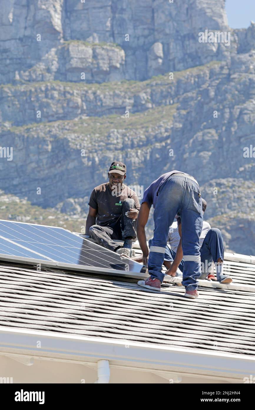 Team installing hybrid grid tied electrical installation of solar ...