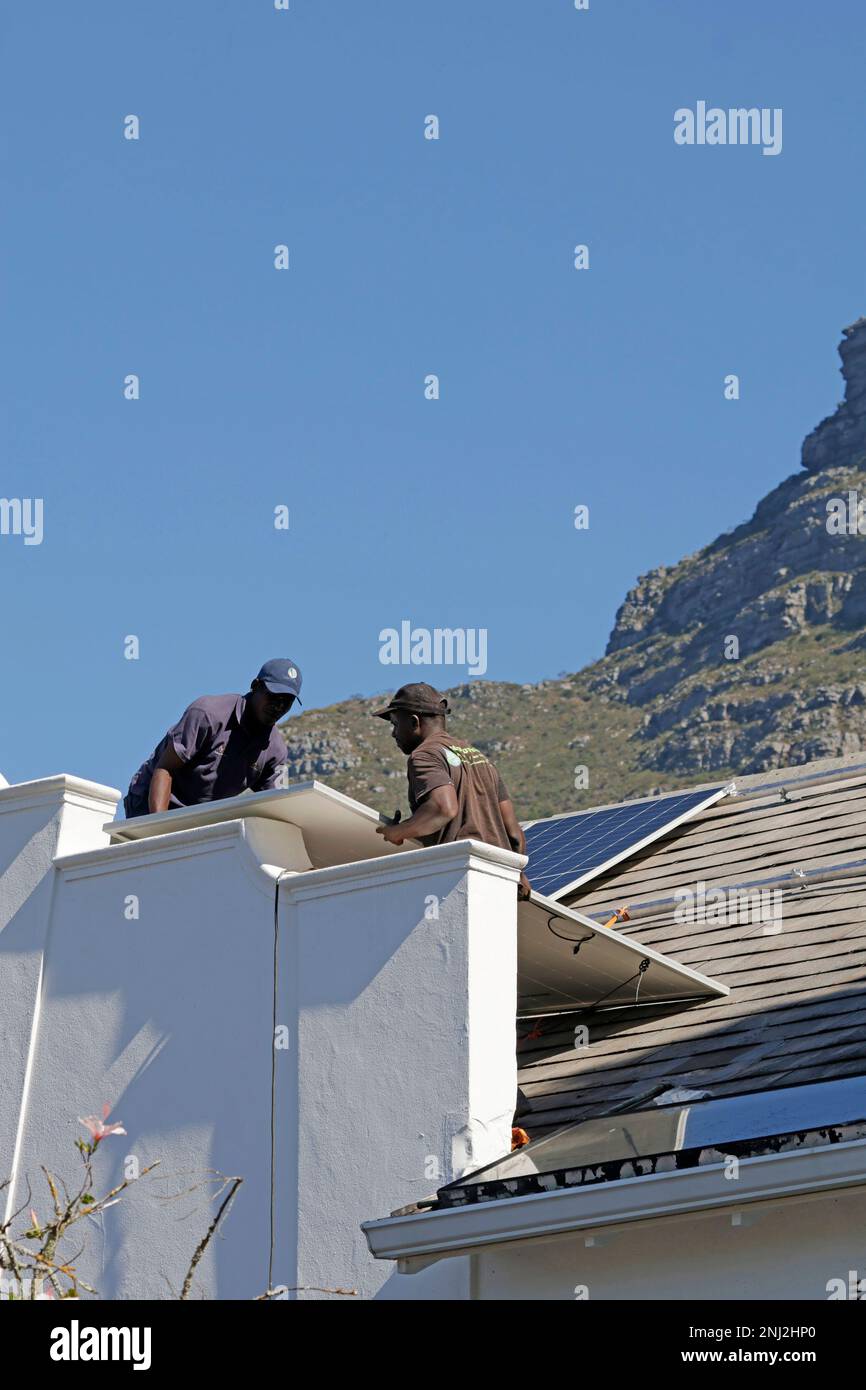 Team installing hybrid grid tied electrical installation of solar ...