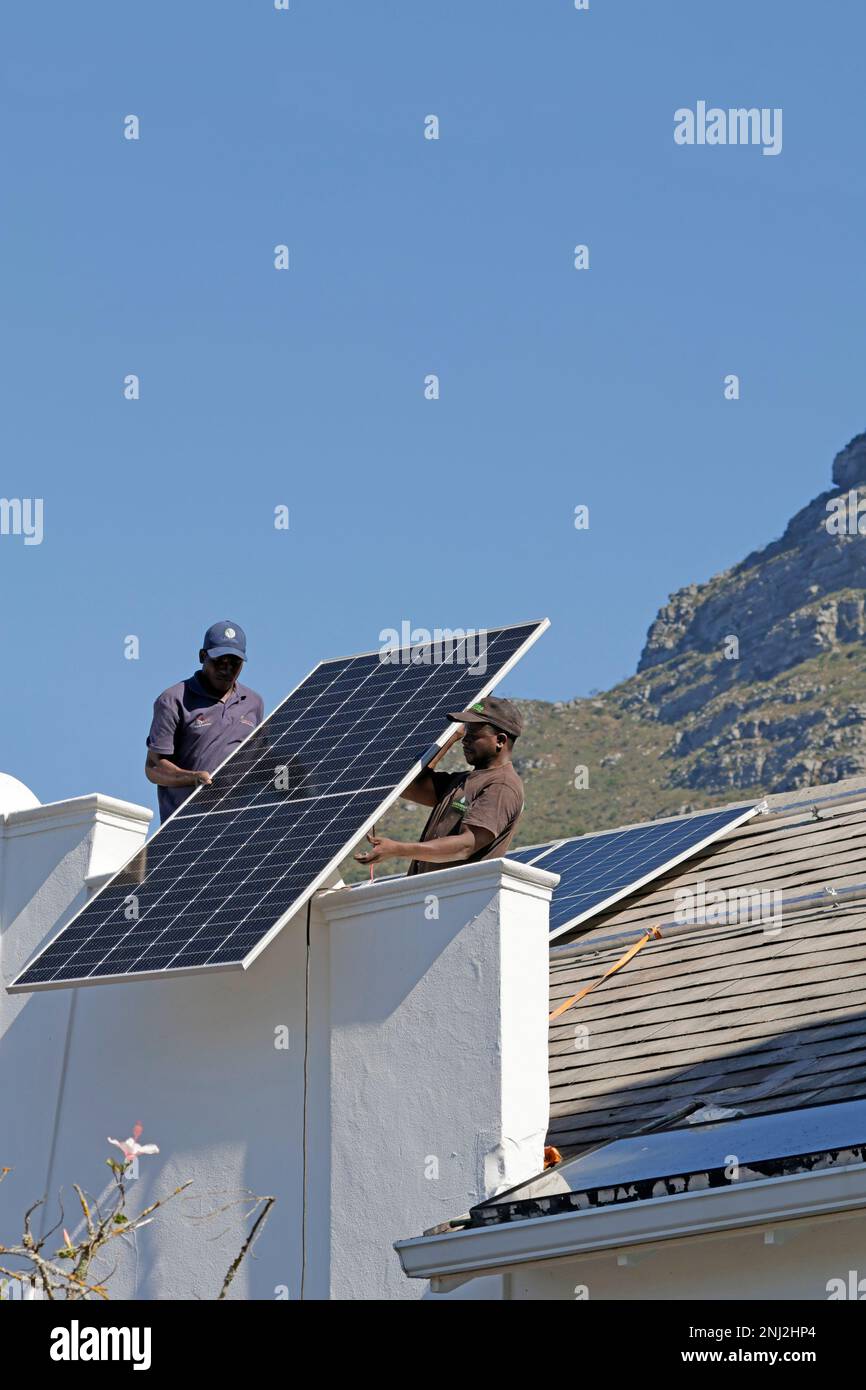 Team installing hybrid grid tied electrical installation of solar ...