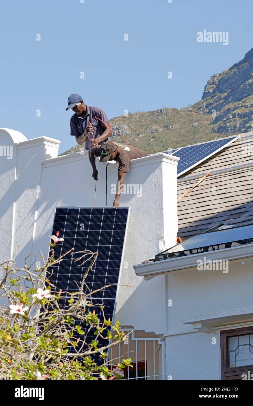 Team installing hybrid grid tied electrical installation of solar ...
