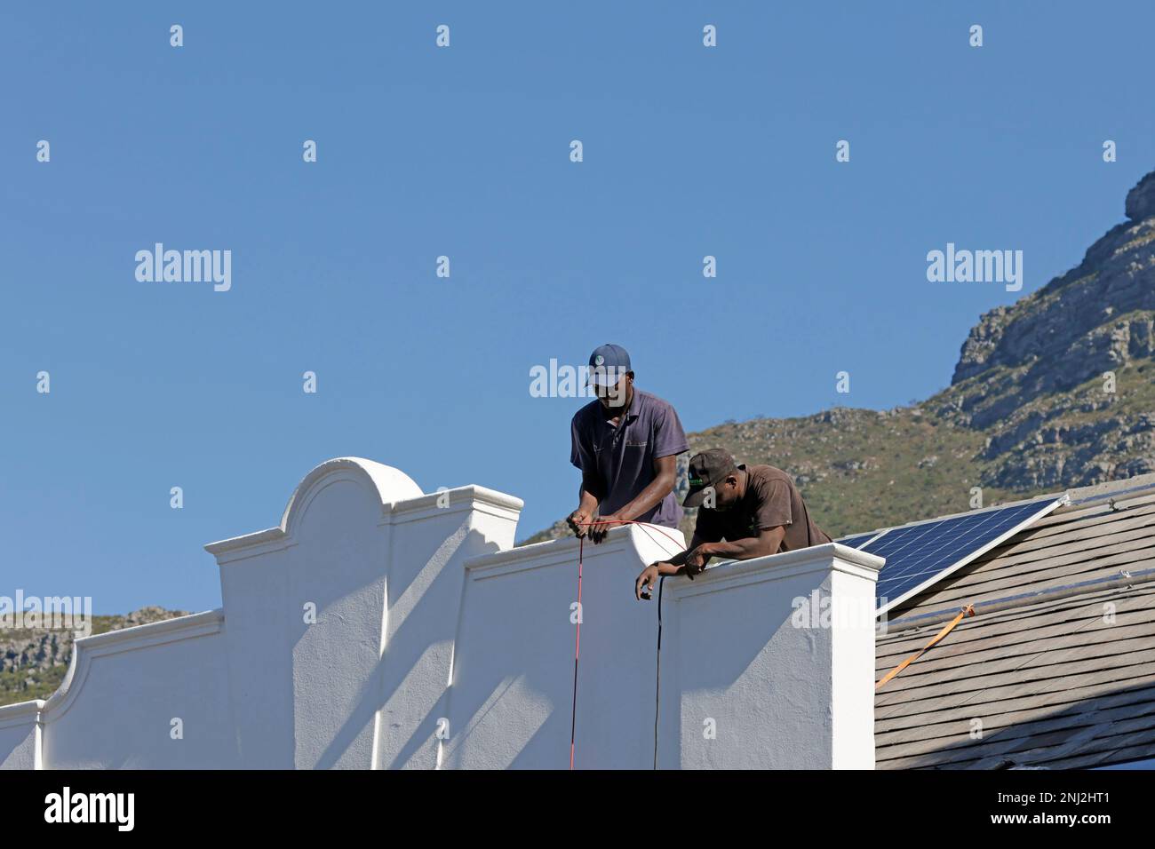 Team installing hybrid grid tied electrical installation of solar ...