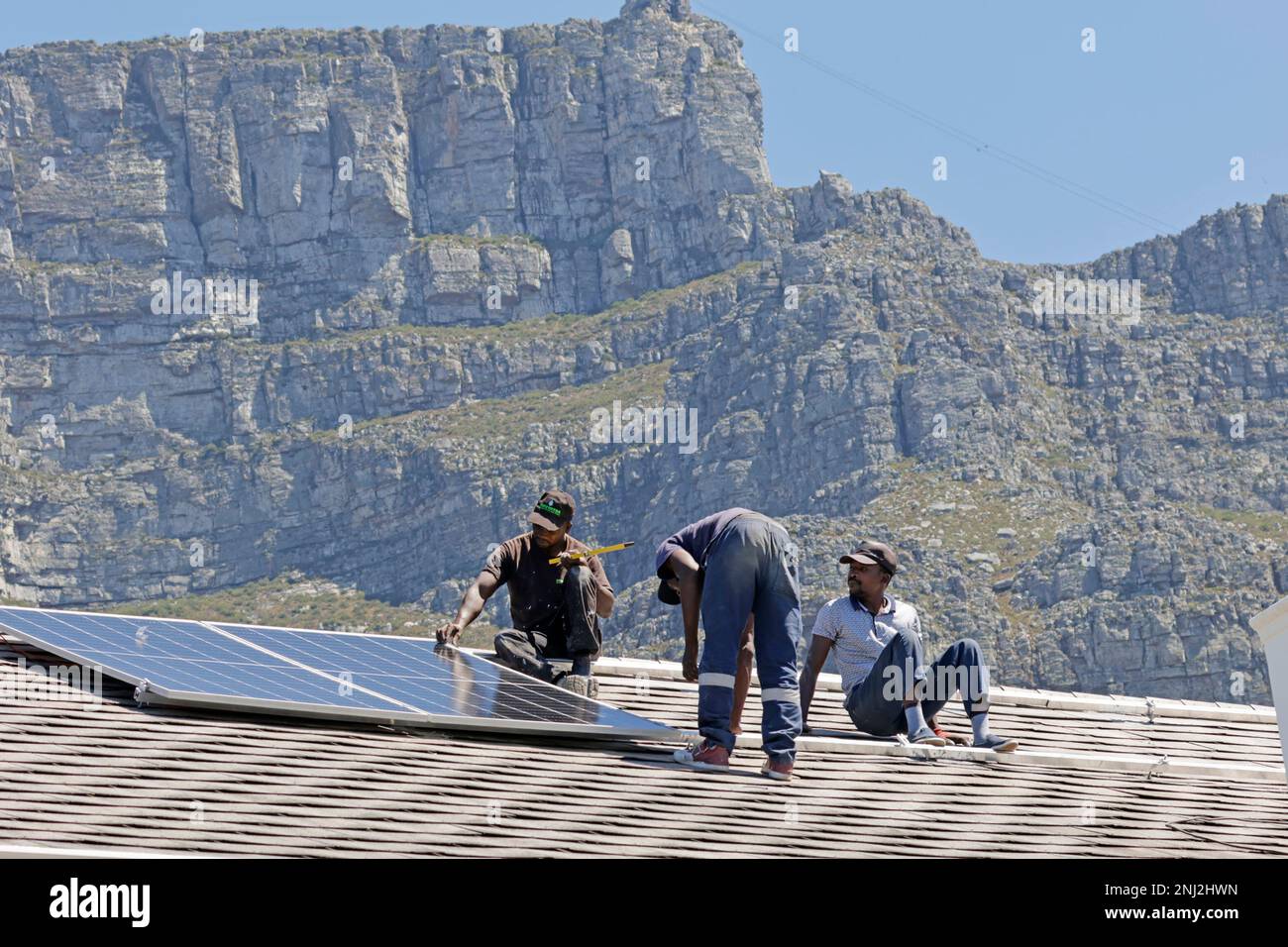 Team installing hybrid grid tied electrical installation of solar ...