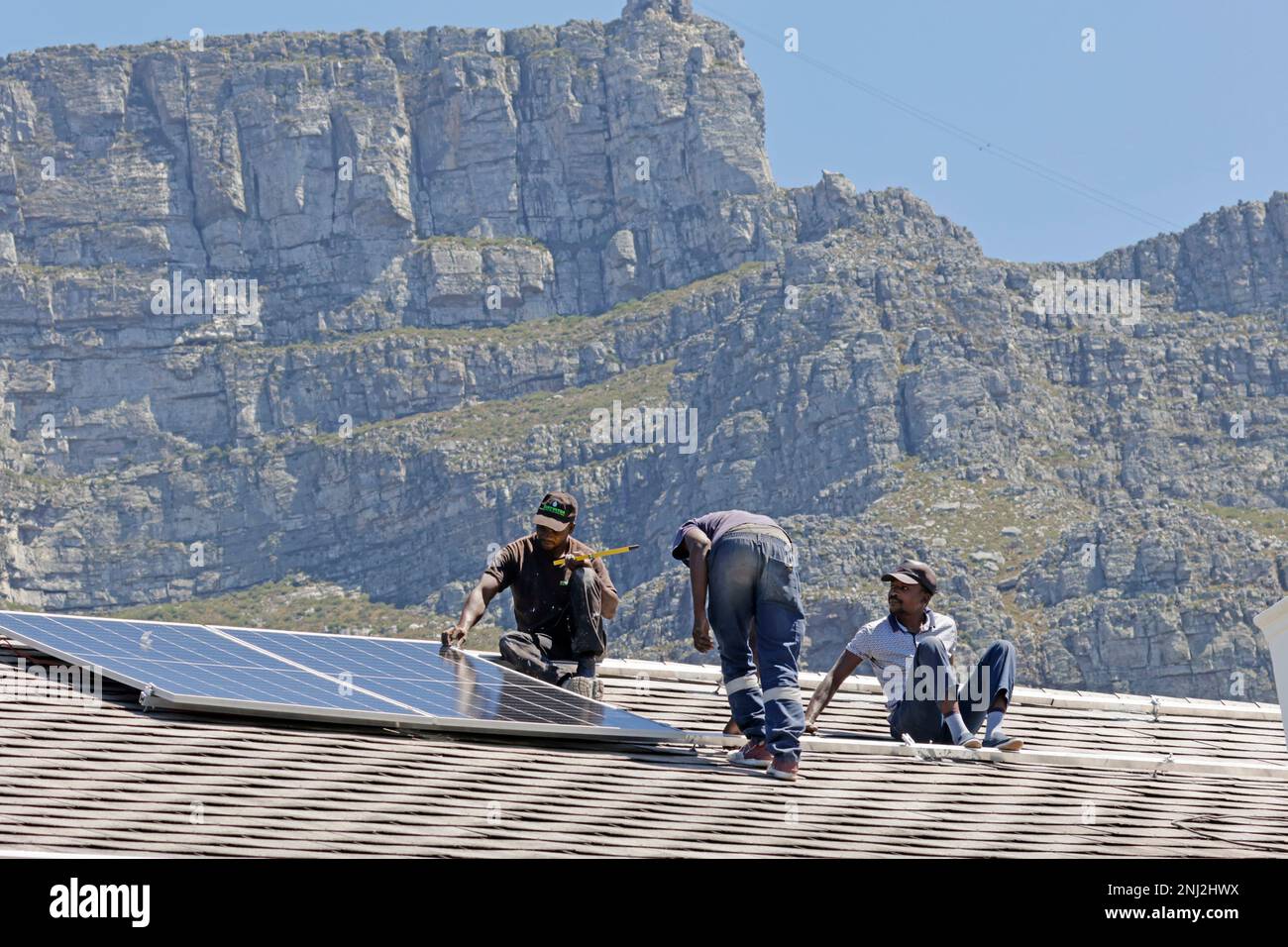 Team installing hybrid grid tied electrical installation of solar ...