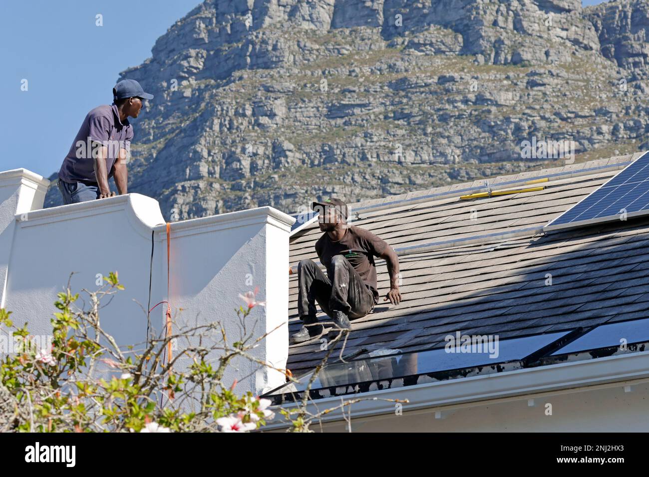 Team installing hybrid grid tied electrical installation of solar ...