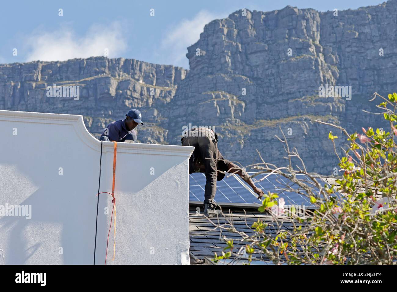 Team installing hybrid grid tied electrical installation of solar ...