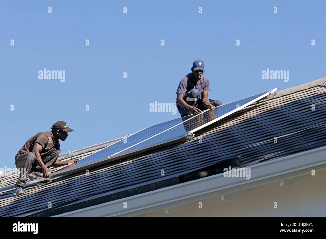Team installing hybrid grid tied electrical installation of solar ...