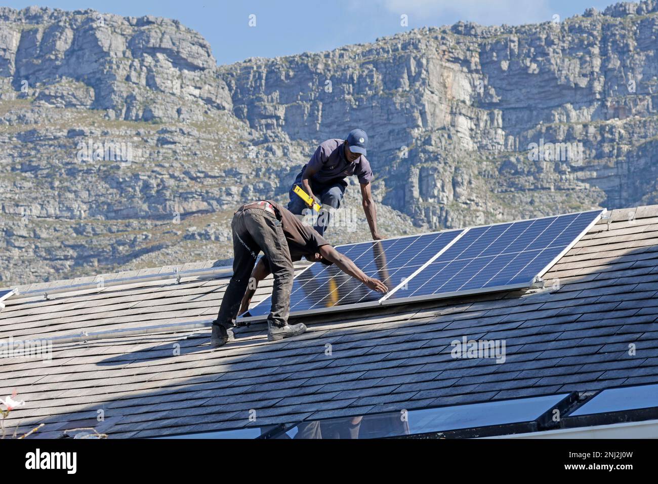 Team installing hybrid grid tied electrical installation of solar ...