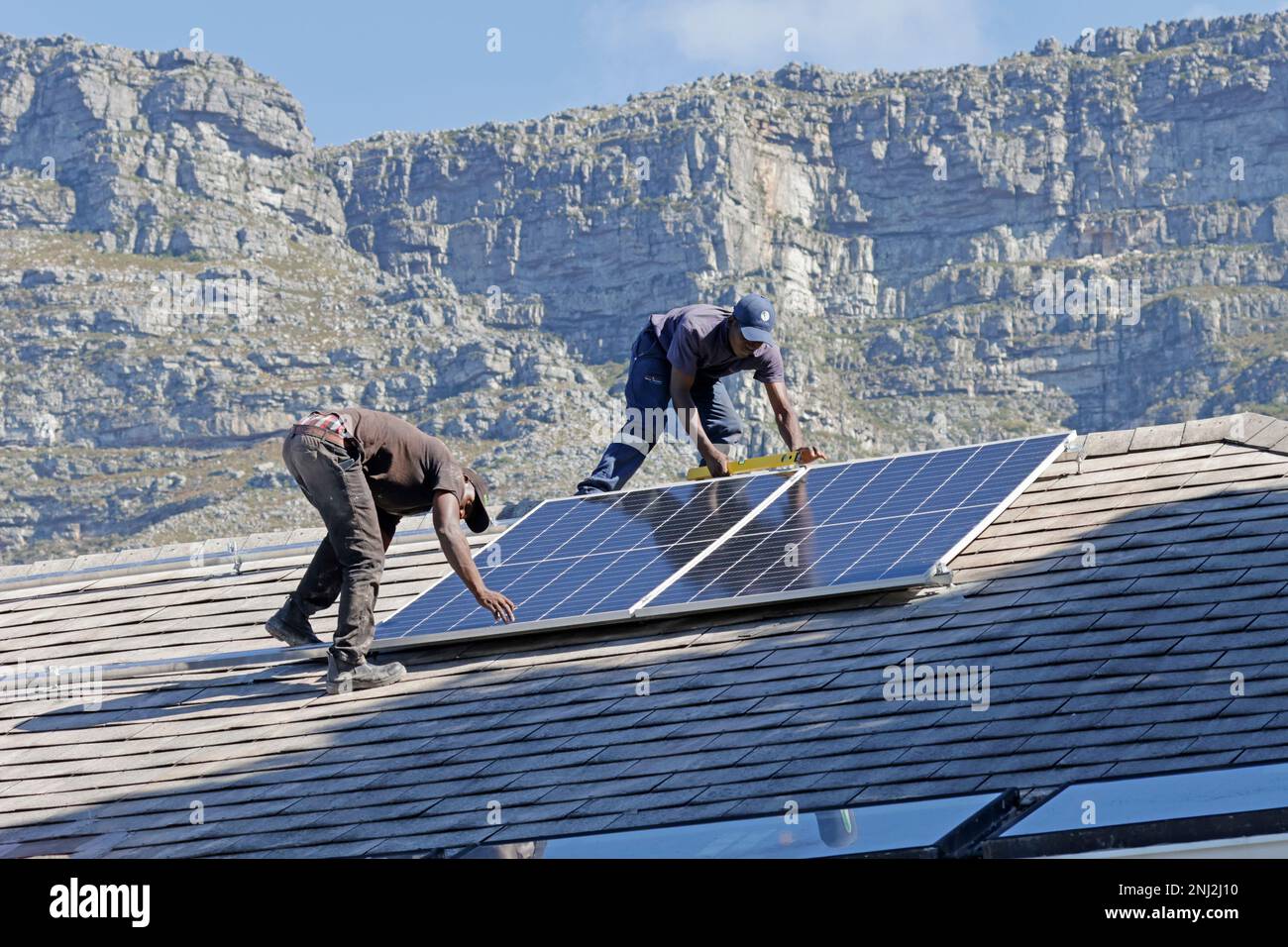 Team installing hybrid grid tied electrical installation of solar ...