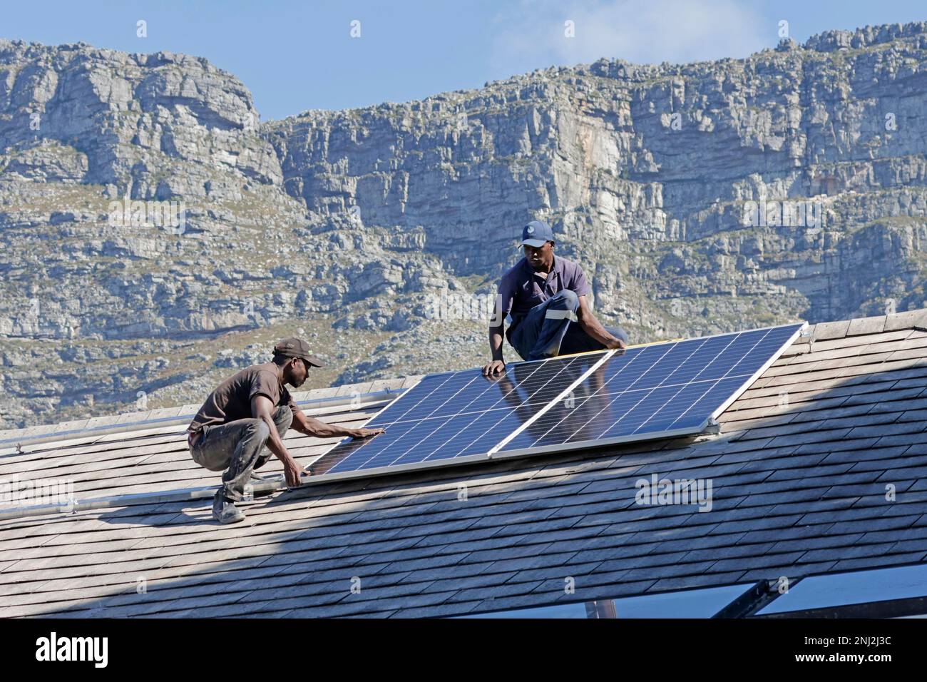Team installing hybrid grid tied electrical installation of solar ...