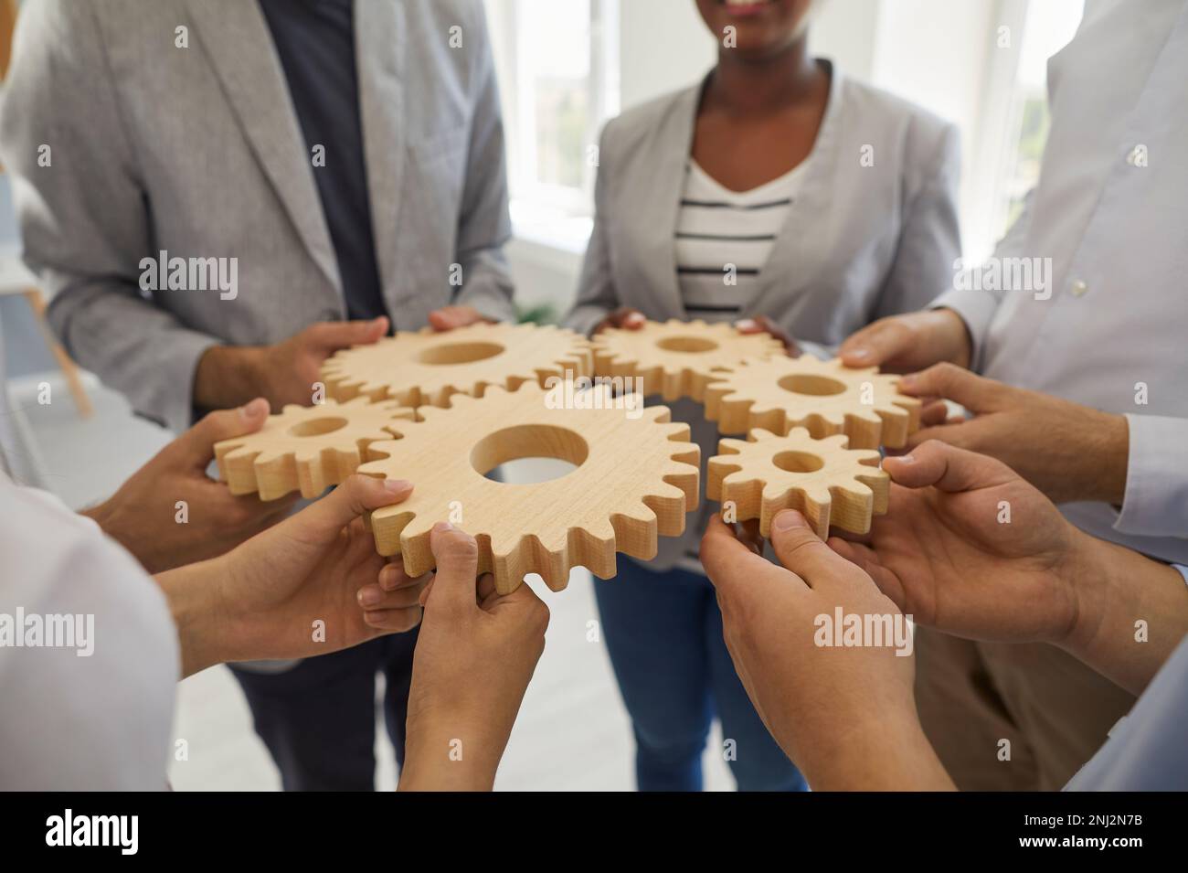 Business team connecting cog wheels to show the concept of cooperation ...