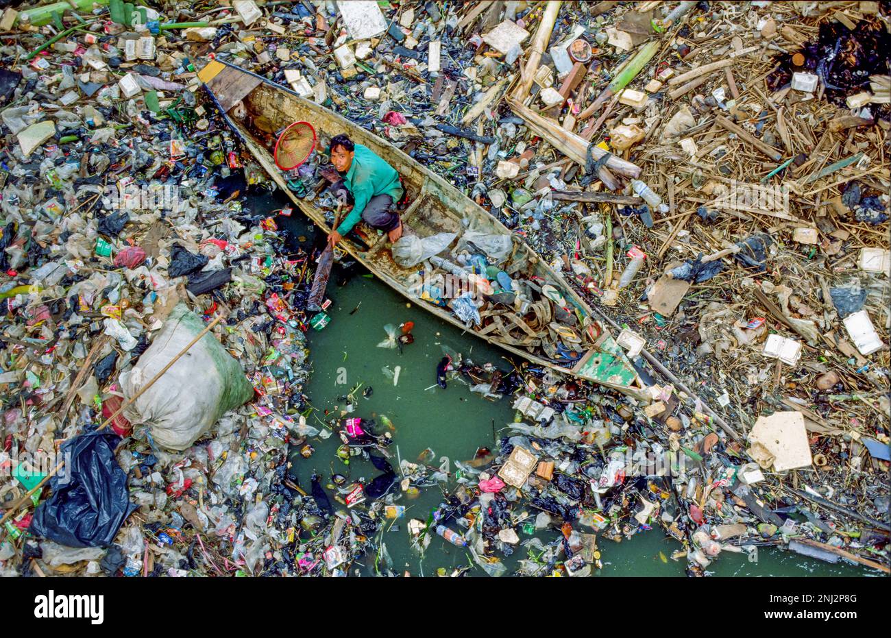 Indonesia,Jakarta, Tanah Abang. Man selects garbage in a canal Stock ...