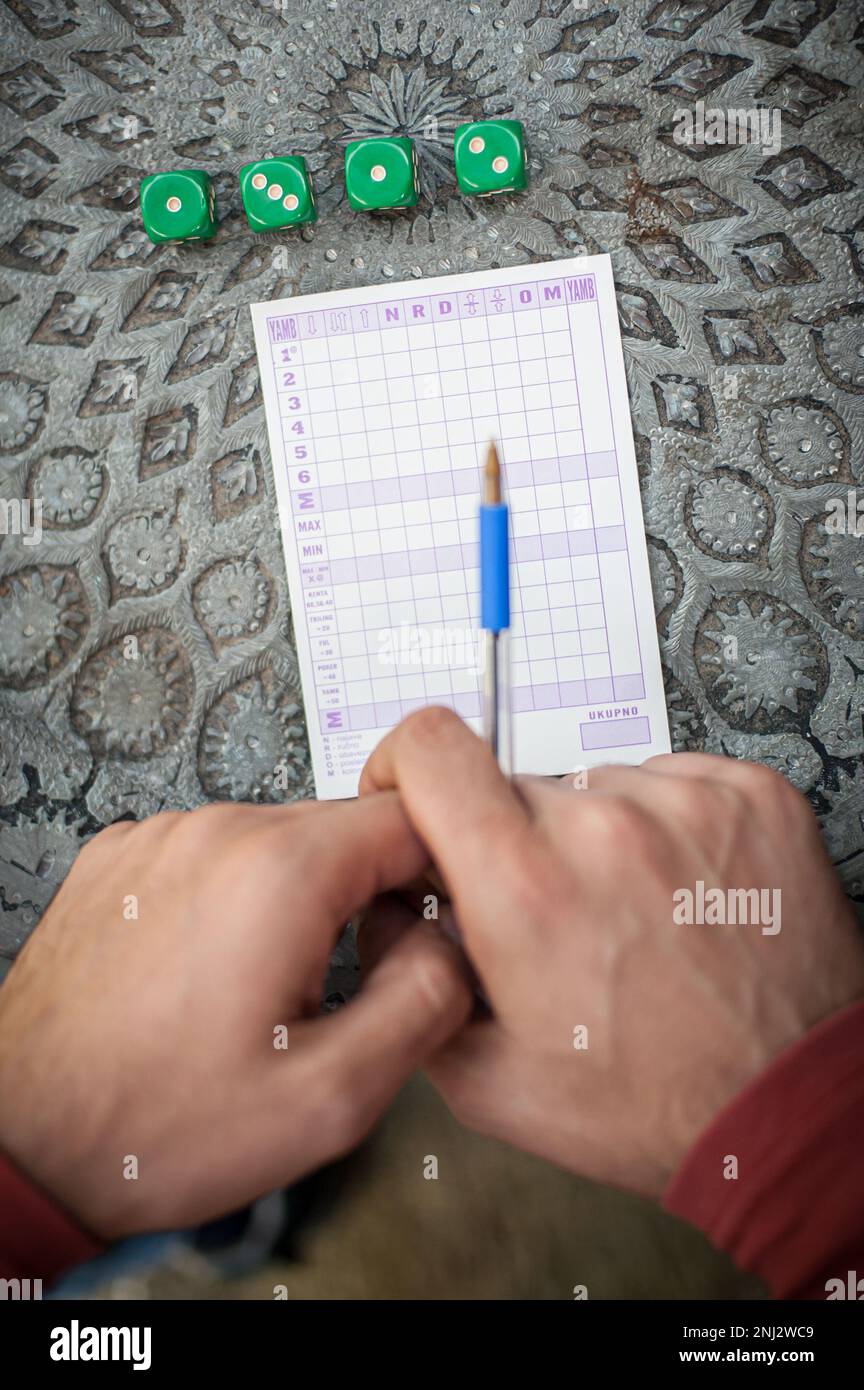 Two friends, men and women are playing yamb game in their free time in ...