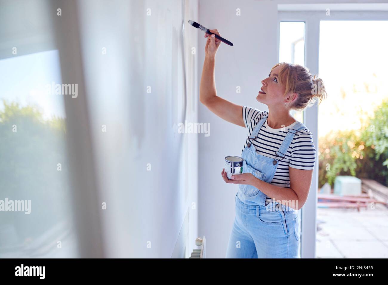 Woman Decorating Room In House Painting Tester Paint Colour Strips On ...
