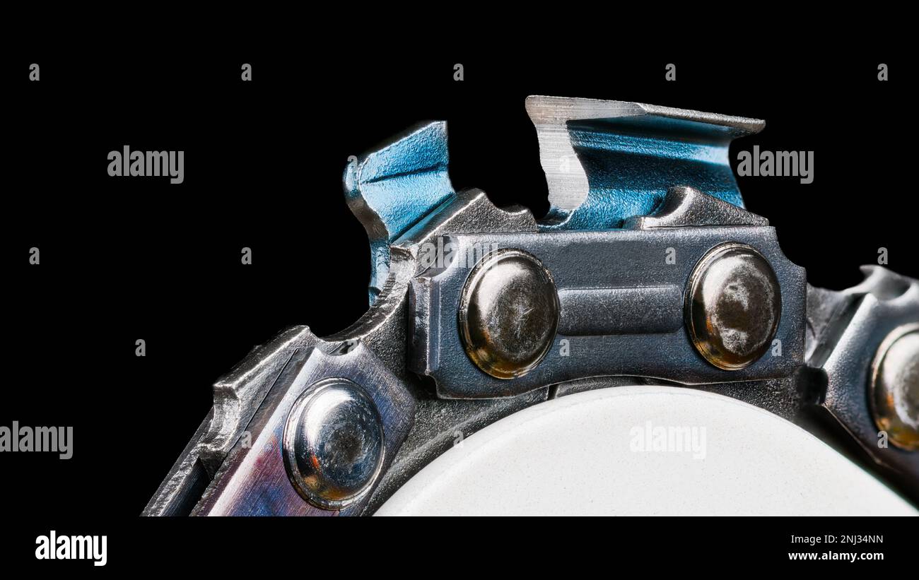 Closeup of sharp steel tooth on saw chain link joined by metal rivets ...