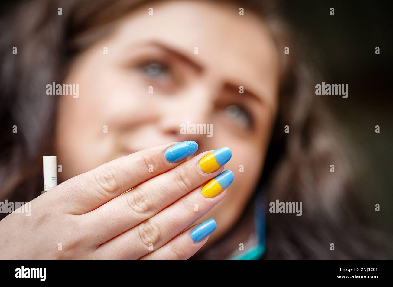 Kiew, Ukraine. 22nd Feb, 2023. A woman shows her fingernails painted in ...
