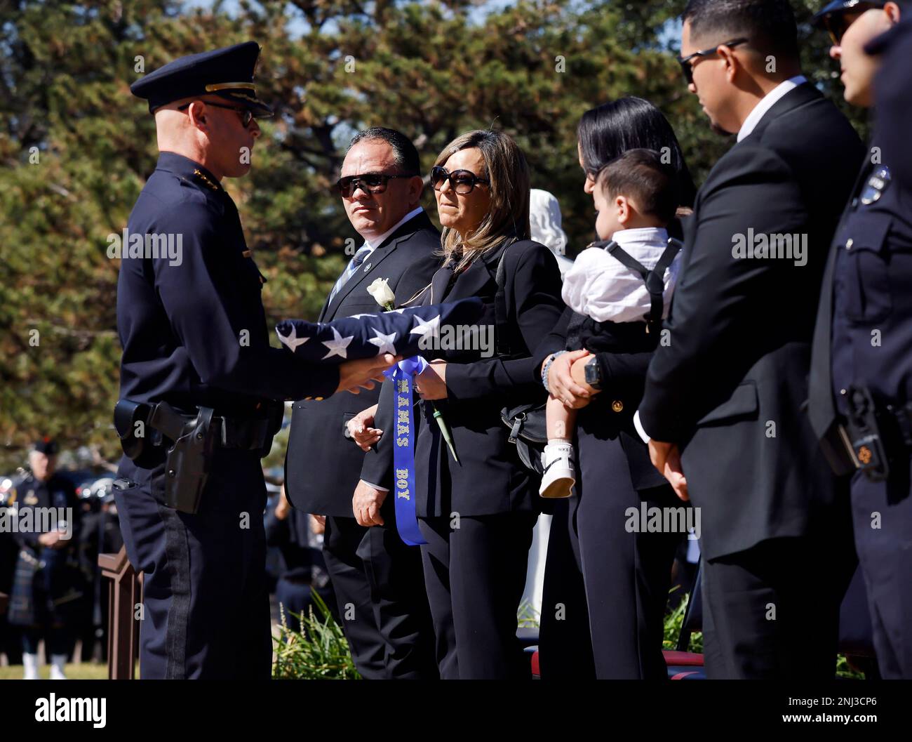 Dallas Police Chief Eddie Garcia, left, presents a folded U.S. flag to ...