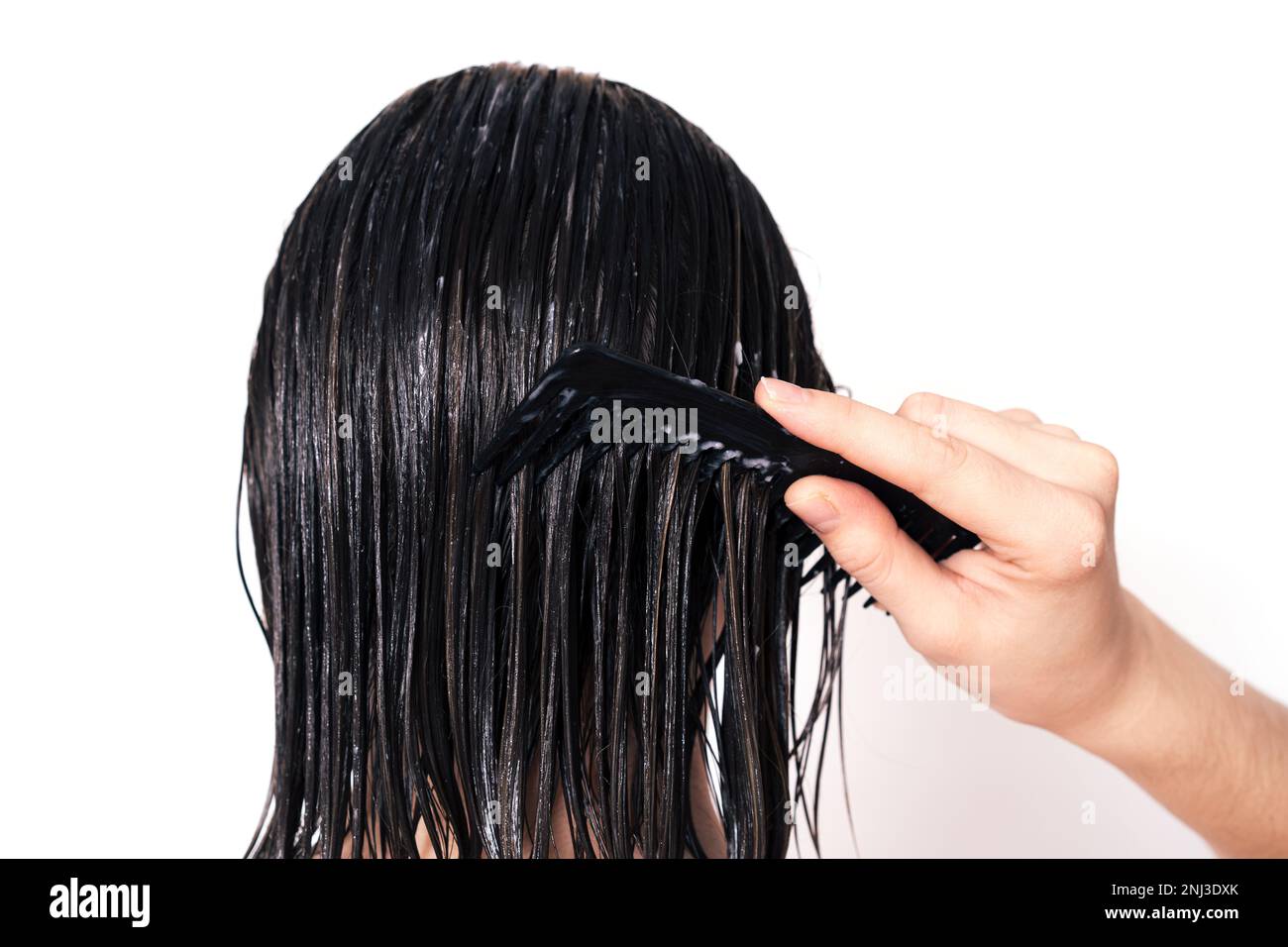 Lady applying hair mask with comb against white background Stock Photo ...