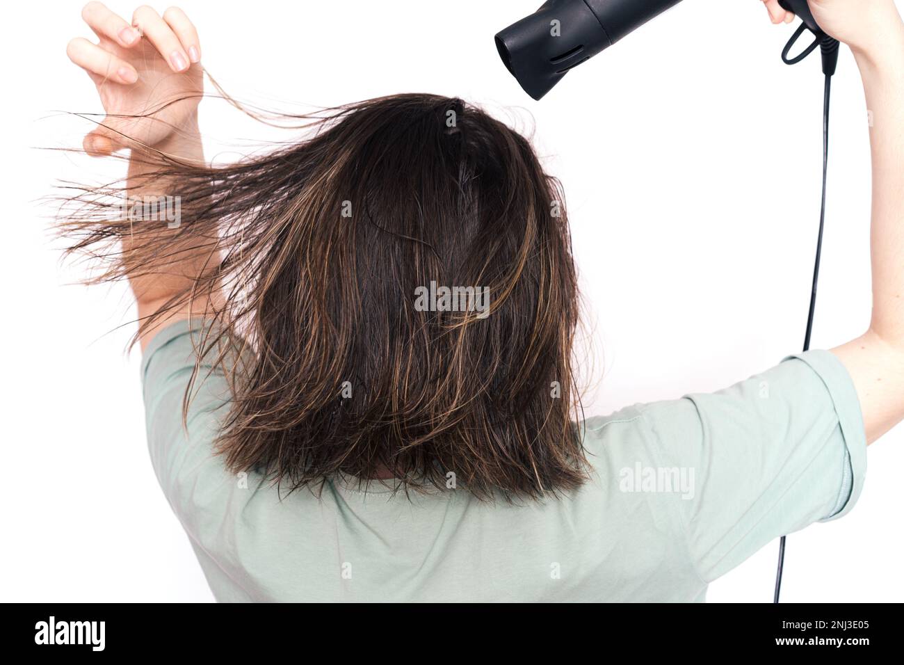 Lady drying her hair against white background Stock Photo - Alamy