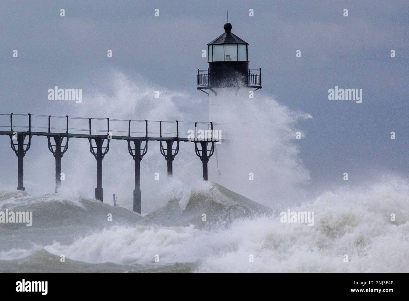 Large waves crash into the north pier outer lighthouse in St. Joseph ...