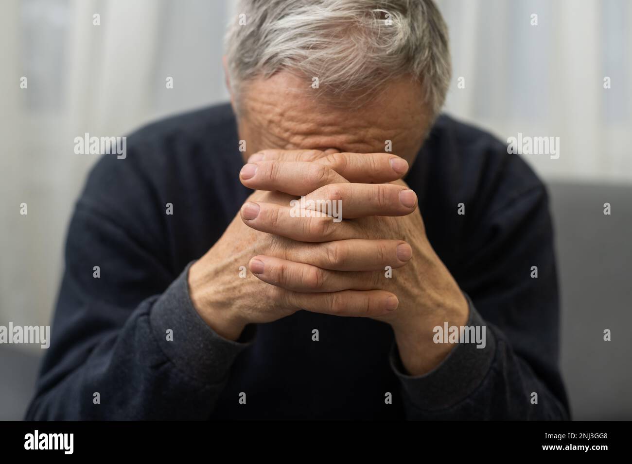 Please, Lord. Nervous worried aged Caucasian man praying on couch at ...