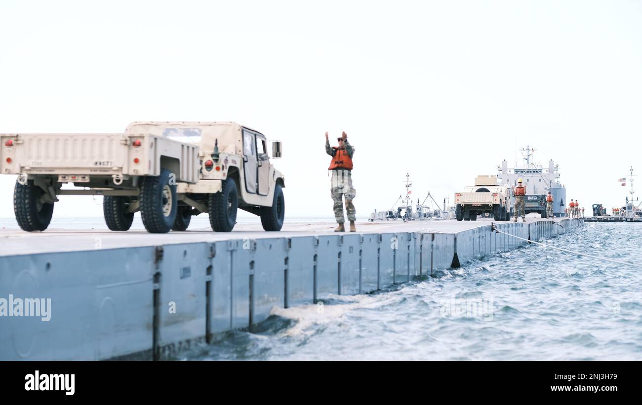 Transporters assigned to the 597th Transportation Brigade are guided by ...