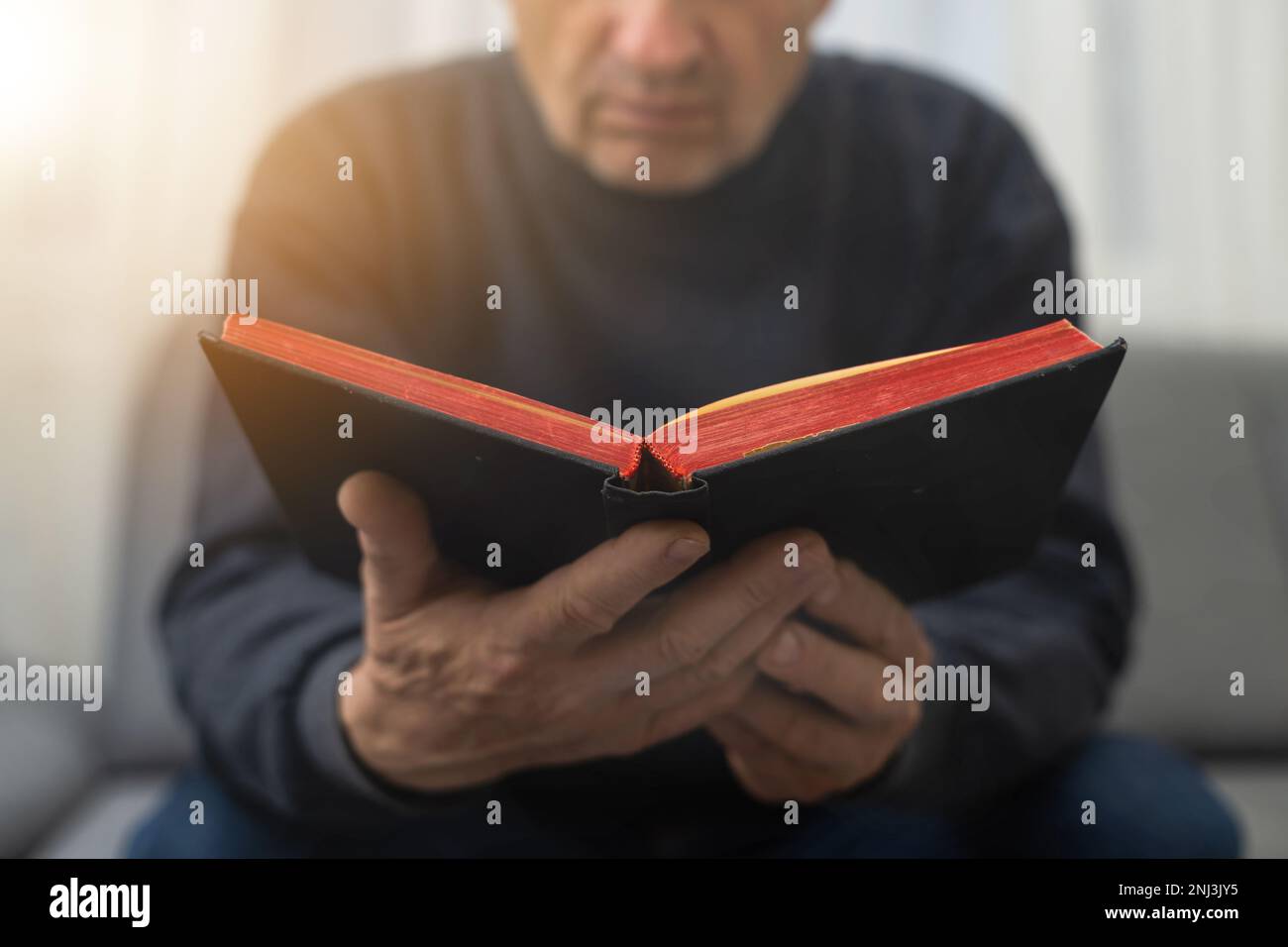 Man praying and reading Bible at home Stock Photo - Alamy