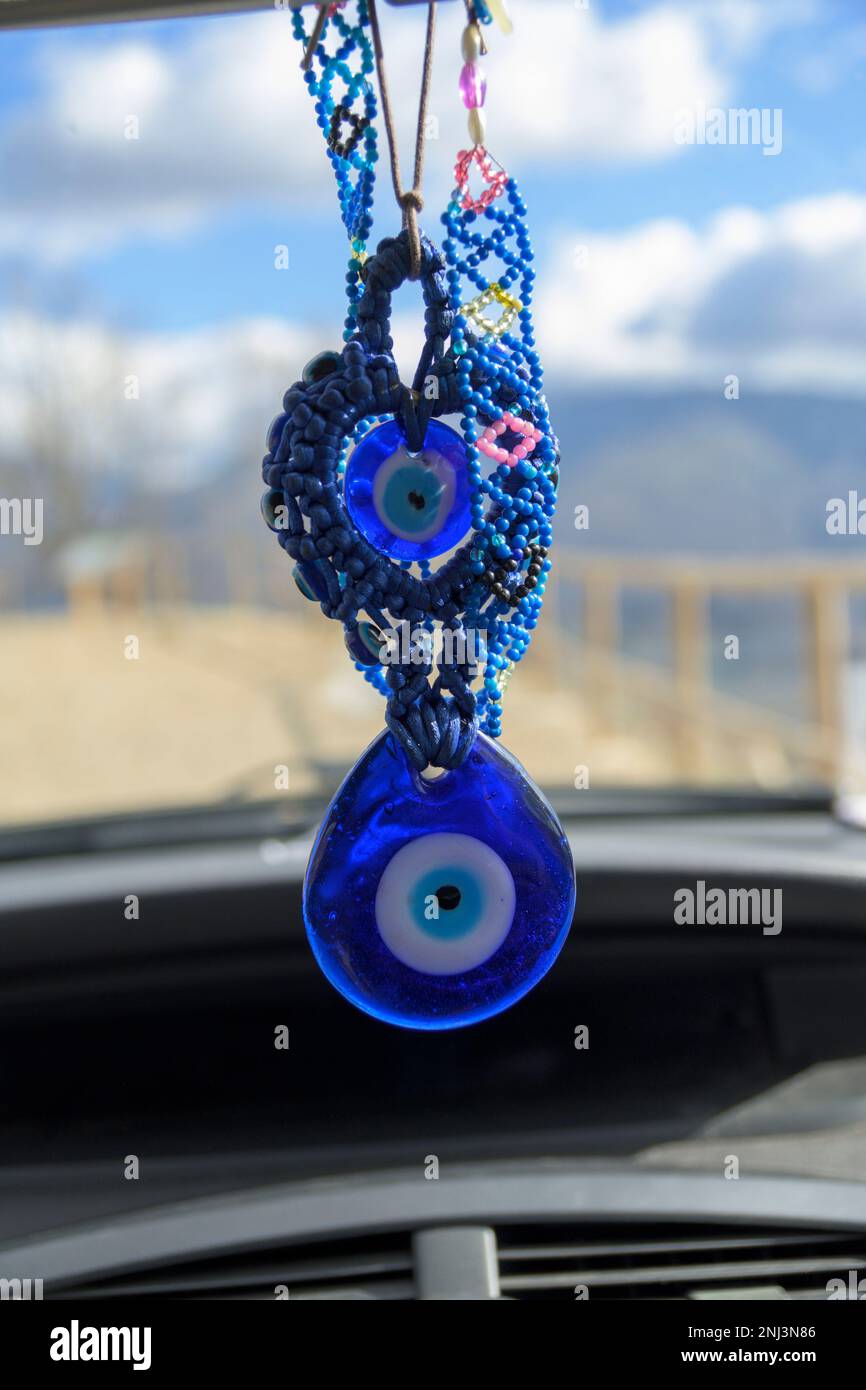 turkish eye necklace hanging vertically on rearview mirror of day car ...