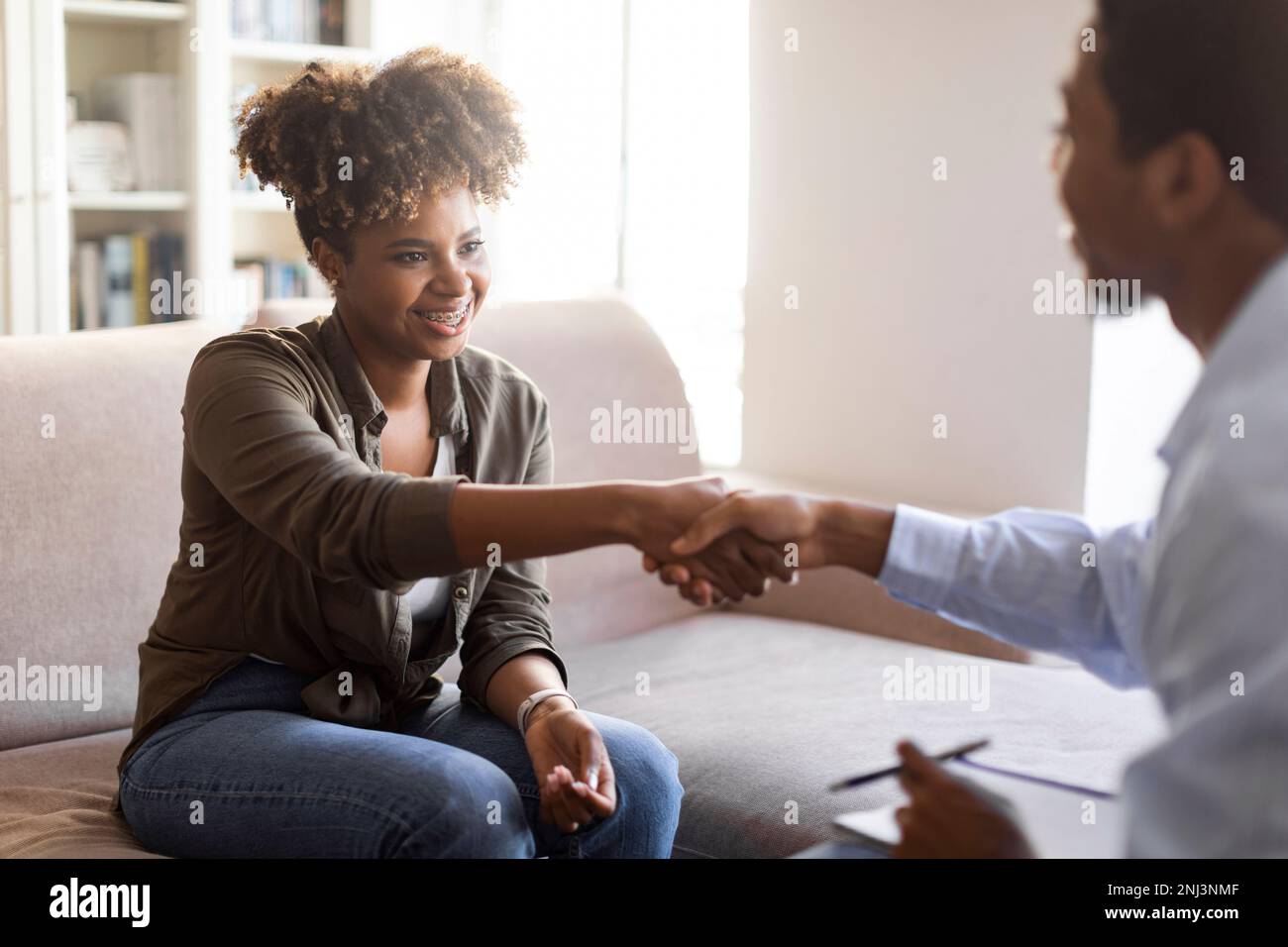 Happy black woman handshaking with man psychologist after therapy ...
