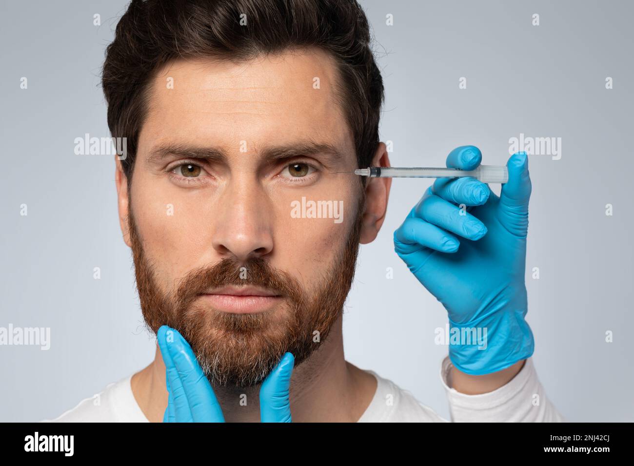 Cosmetologist doctor making botox injection for eyes area to middle ...