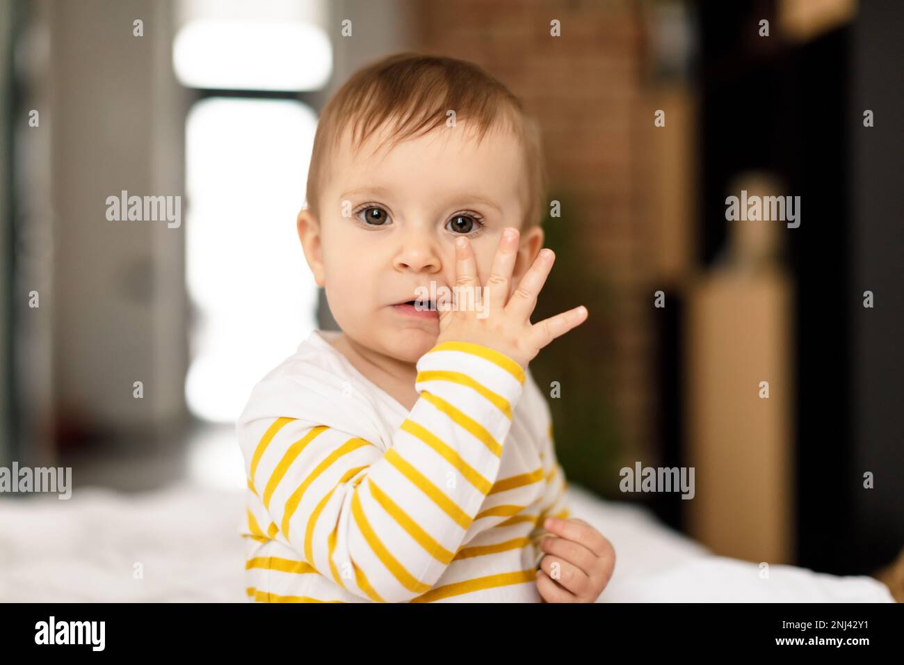 Teething concept. Portrait of little baby girl sitting on white ...
