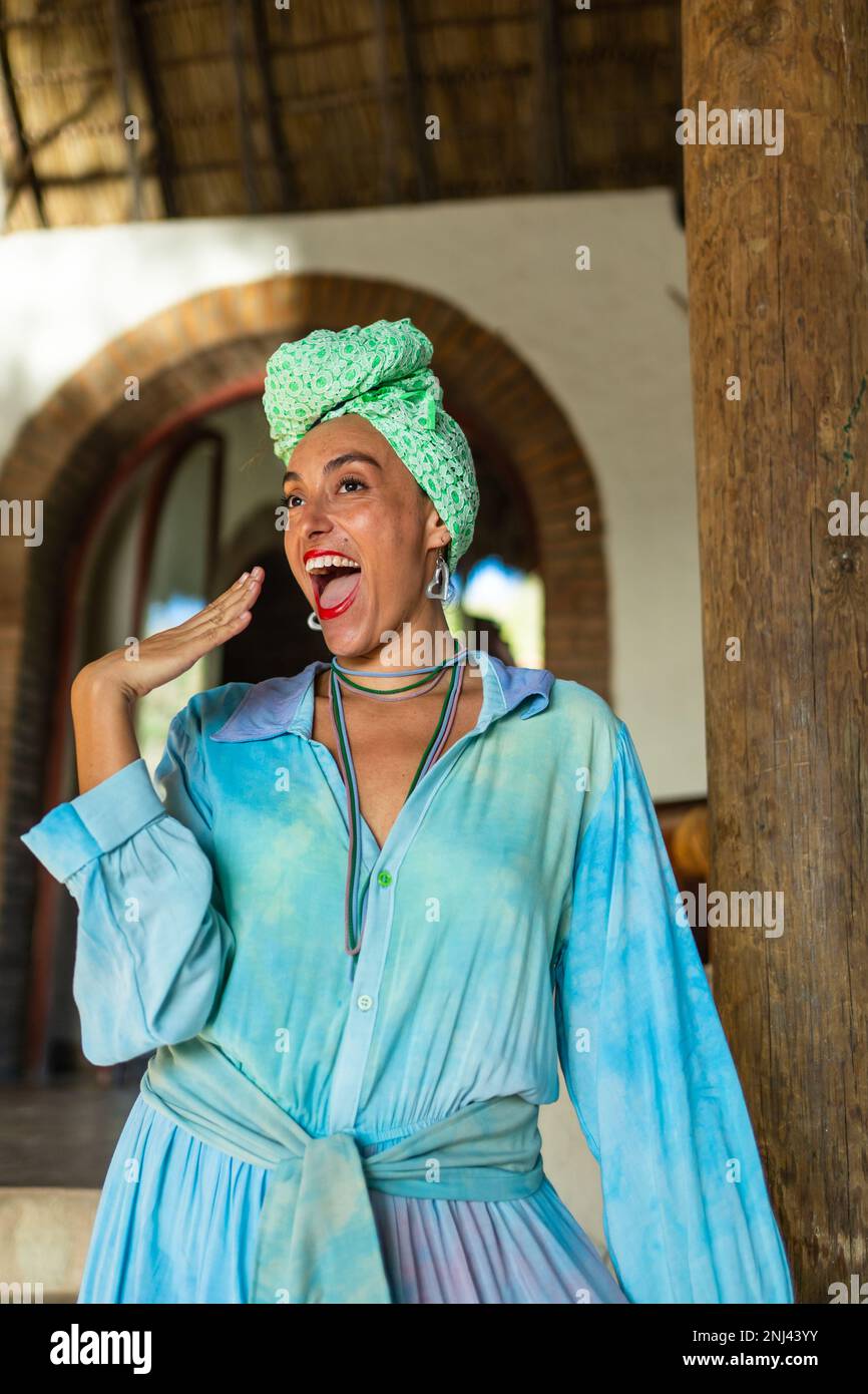Vertical photo of an expressive model posing with a blue Caribbean ...