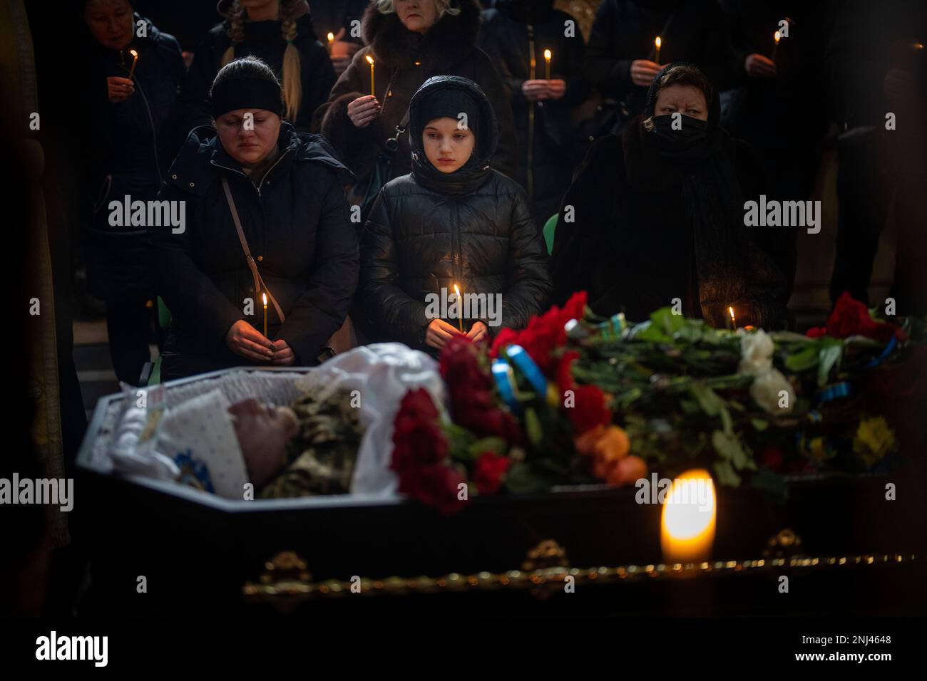 Tamara, left, with her daughter Sophia, sits next to the body of her ...