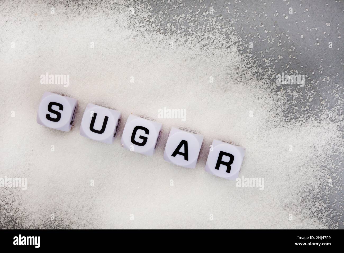 Sugar written in letter dice on white sugar granules Stock Photo - Alamy